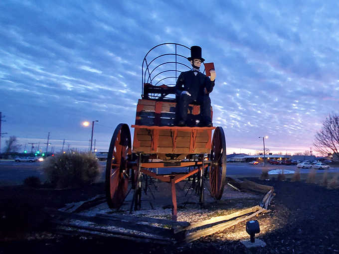 As dusk settles over Route 66, the giant wagon takes on an almost magical quality, silhouetted against the twilight sky.