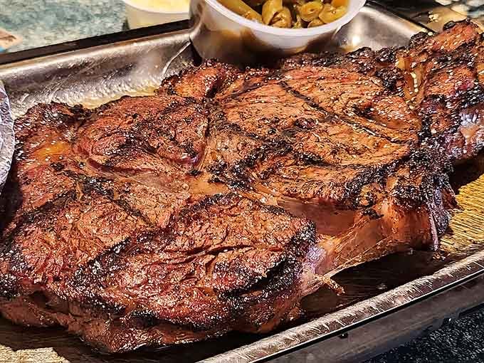 Behold the magnificent beast in all its charred glory, a ribeye so substantial it could probably be seen from space with proper lighting.