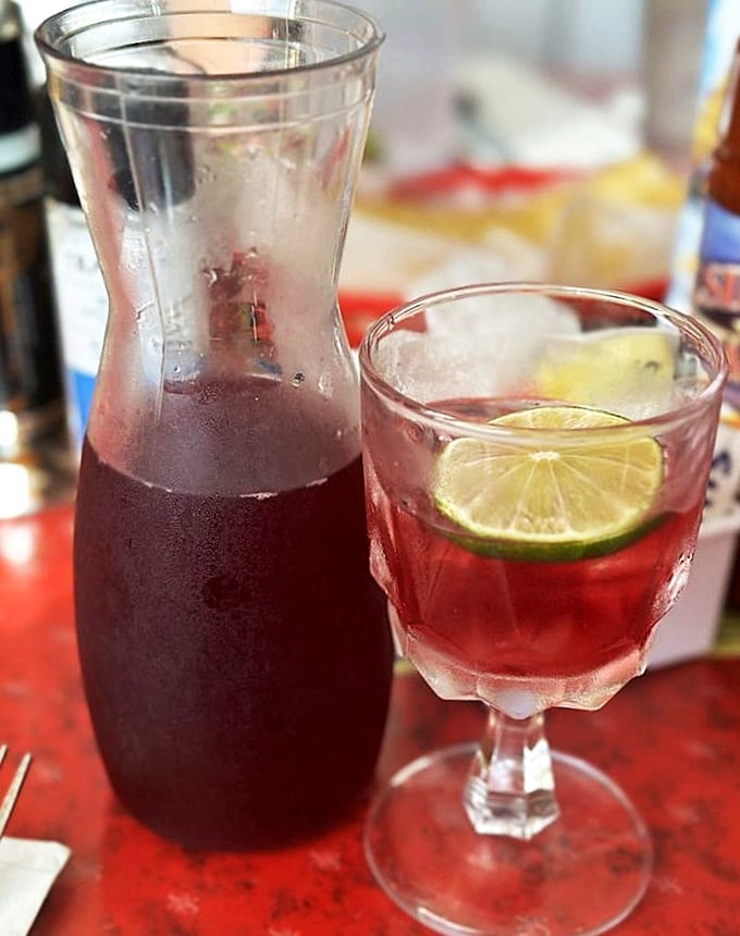 Ruby red liquid happiness served with a lime wedge &ndash; this isn't just sangria, it's a spiritual experience in a glass.