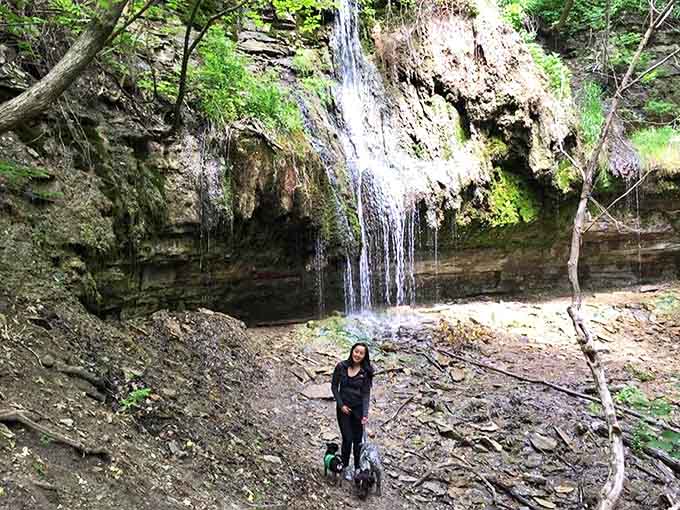 A visitor finds her moment of zen beneath the falls, where the symphony of rushing water drowns out the distant hum of the city.