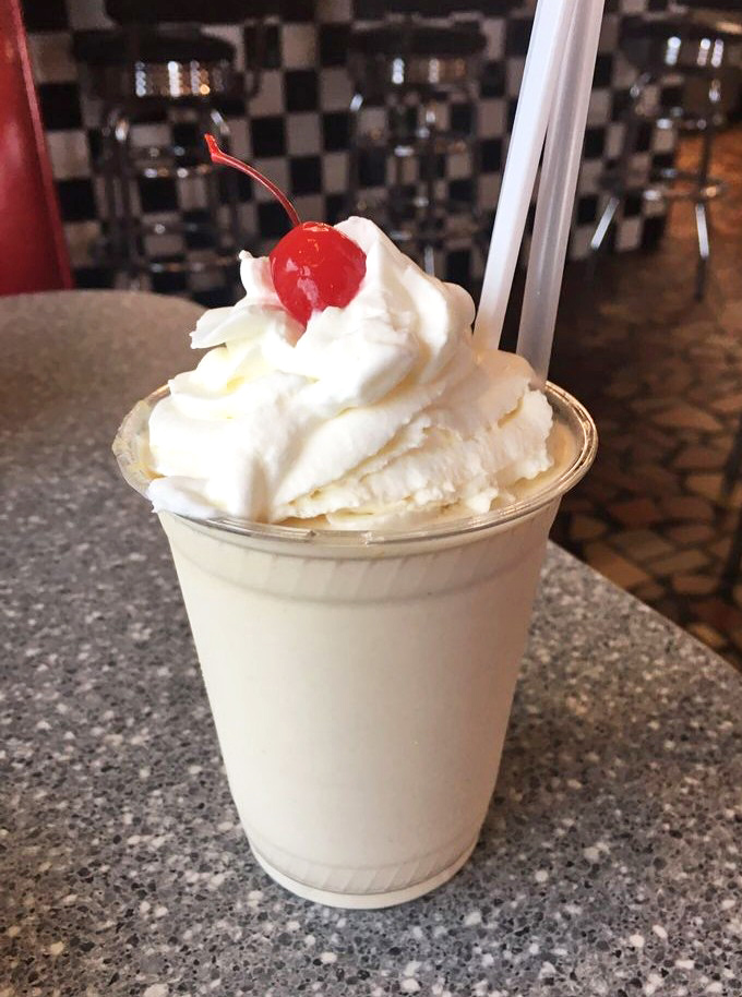 This isn't just a milkshake; it's a creamy cloud of peanut butter perfection topped with whipped cream and that obligatory cherry on top.