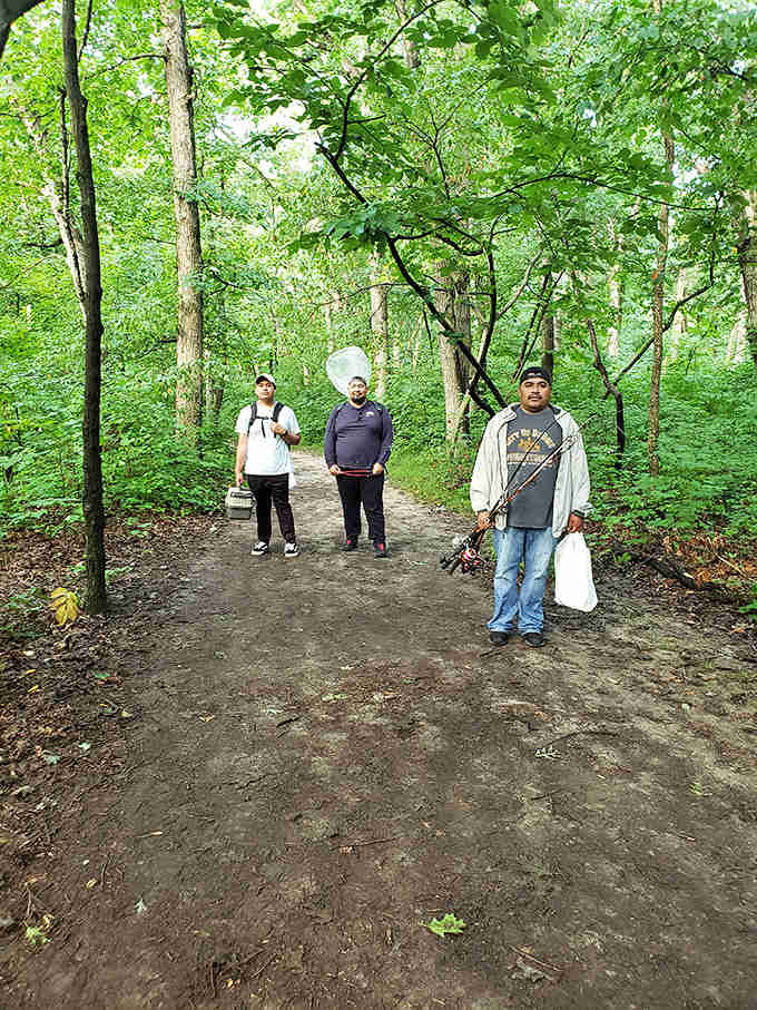 Fellow nature enthusiasts pause along the trail, fishing gear in hand &ndash; proof that Starved Rock's treasures attract visitors from all walks of life.
