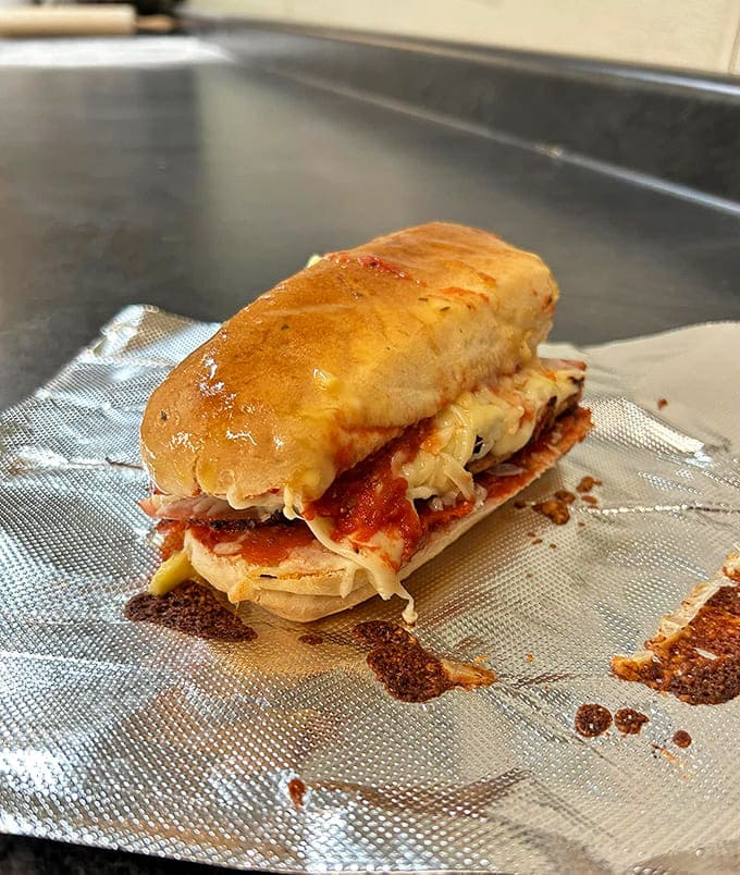 Fresh subs waiting in the warmer like edible treasure, each one packed with enough ingredients to require an engineering degree to eat properly.