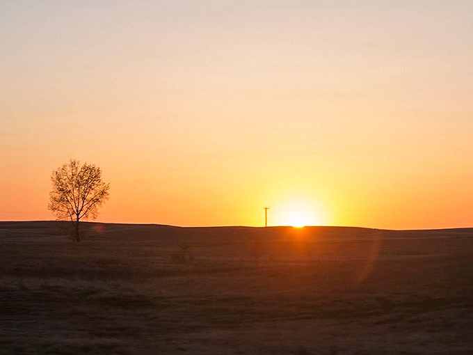 A breathtaking sunset paints the Wisconsin prairie in golden hues, one of countless natural spectacles visible from the train's windows.