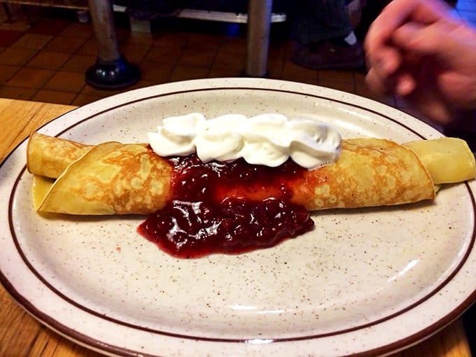 Swedish Pancakes arrive like delicate edible lace, thin and tender with warm lingonberries that add the perfect tart-sweet balance to every bite.