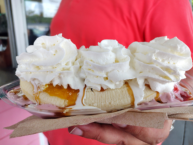 A banana split that defies gravity &ndash; vanilla ice cream nestled against fresh banana, crowned with a mountain of whipped cream that touches the clouds.
