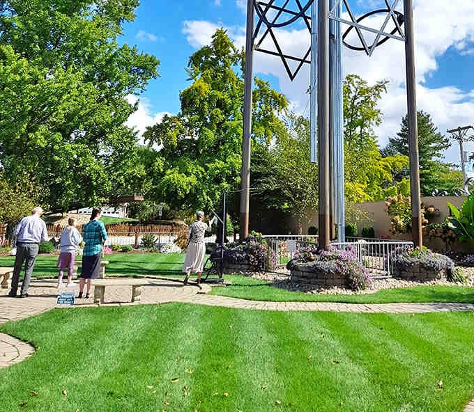 Visitors gather in awe beneath the towering chime, their upturned faces capturing that perfect blend of disbelief and delight.