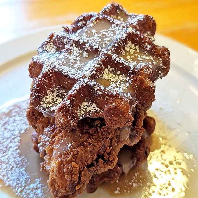 Architecture in food form! Crispy waffle foundations support perfectly seasoned fried chicken, all swimming in that life-changing bourbon maple toffee sauce.