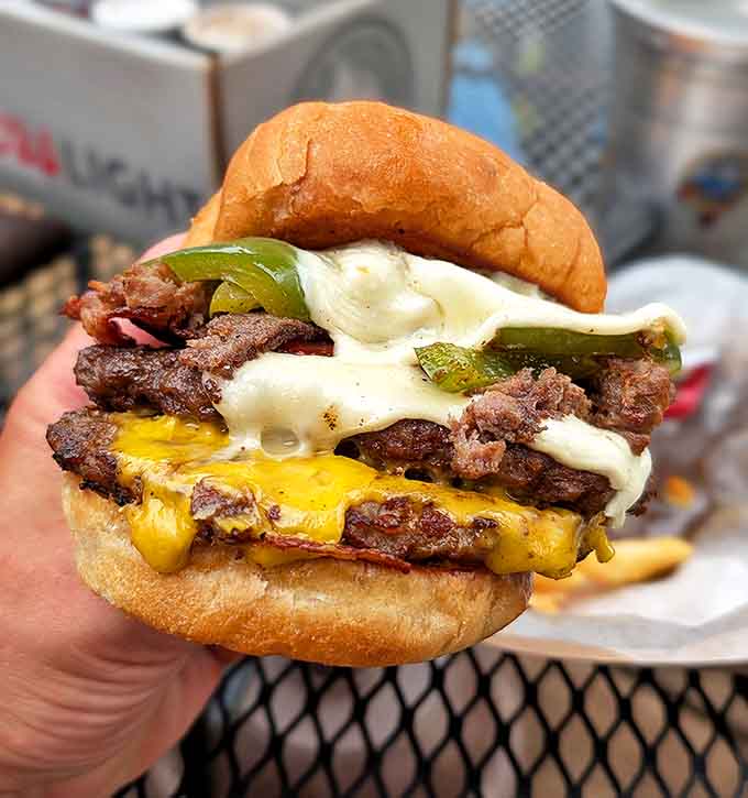 This isn't just a burger &ndash; it's edible architecture. Layers of beef, cheese, and veggies create a masterpiece that requires both hands.