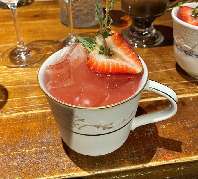 This isn't your grandmother's teacup – unless grandma was secretly running hooch during Prohibition. Strawberry garnish adds a modern twist.