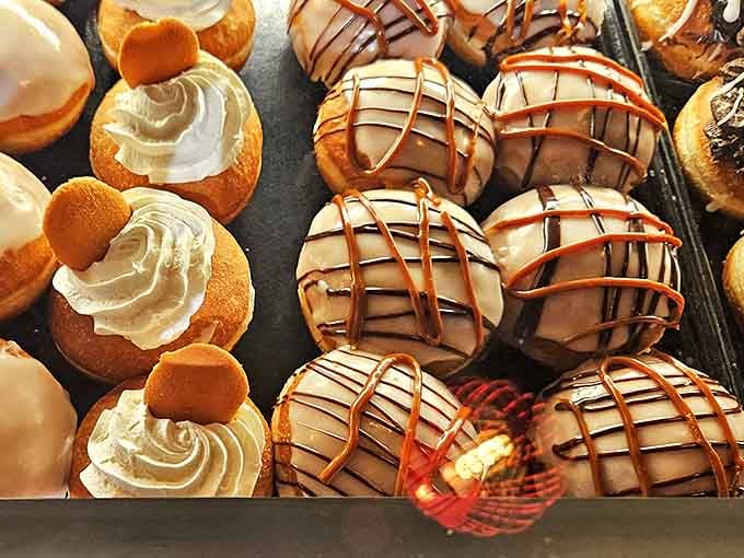 These aren't just donuts &ndash; they're edible art pieces where cream filling peeks out playfully, daring you to resist their charm.