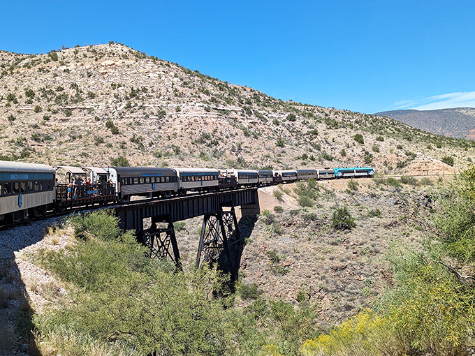 The train gracefully traverses a historic trestle bridge, a testament to engineering ingenuity that turns "how did they build that?" into "thank goodness they did!"