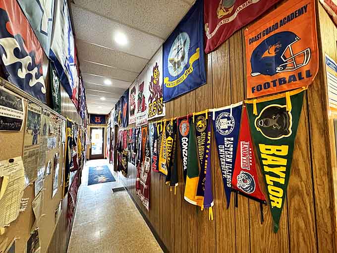 The hallway of collegiate memories showcases decades of school pride, with pennants from universities across the country creating a vibrant tapestry.