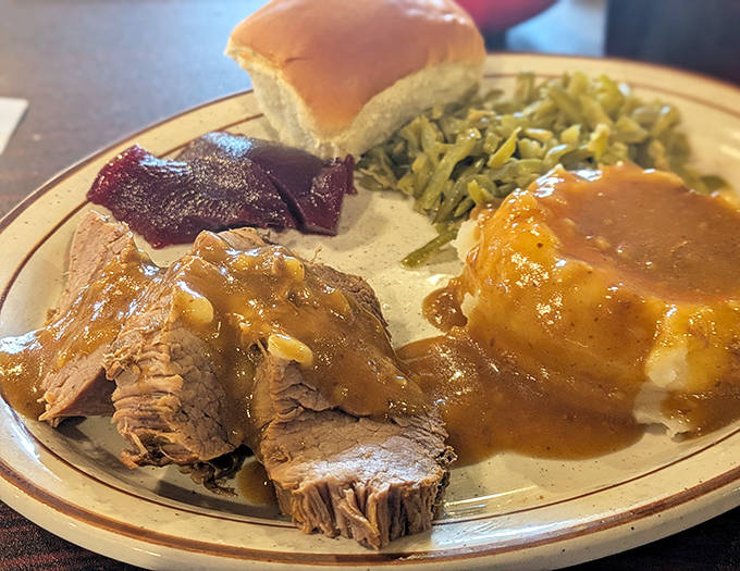 A plate that tells Minnesota's story – tender pot roast and fluffy mashed potatoes swimming in gravy, with green beans and lingonberry for balance.