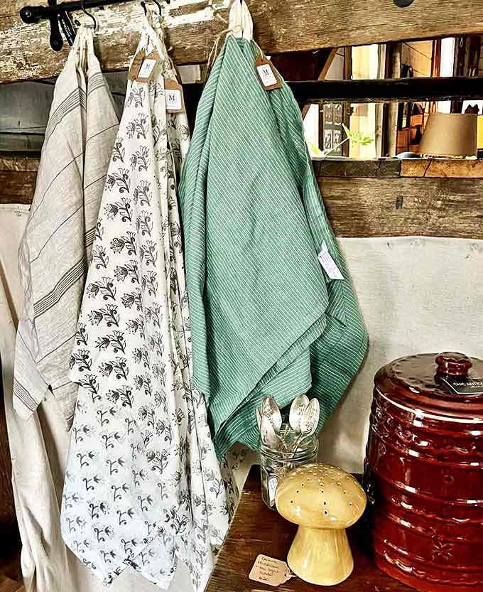 Vintage kitchen linens hang with purpose and history, their muted patterns and natural fibers telling stories of countless family meals and celebrations past.
