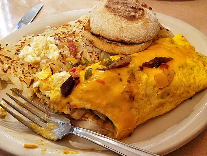 This isn't just an omelet, it's a masterpiece of egg architecture, stuffed with fresh ingredients and paired with perfectly crispy hashbrowns.
