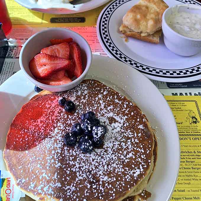 Pancakes that require a commitment, fresh berries that add a touch of virtue, and enough powdered sugar to make your dentist wince.