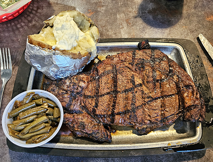 A perfectly grilled ribeye that could feed a small family, accompanied by green beans that actually taste like vegetables should.