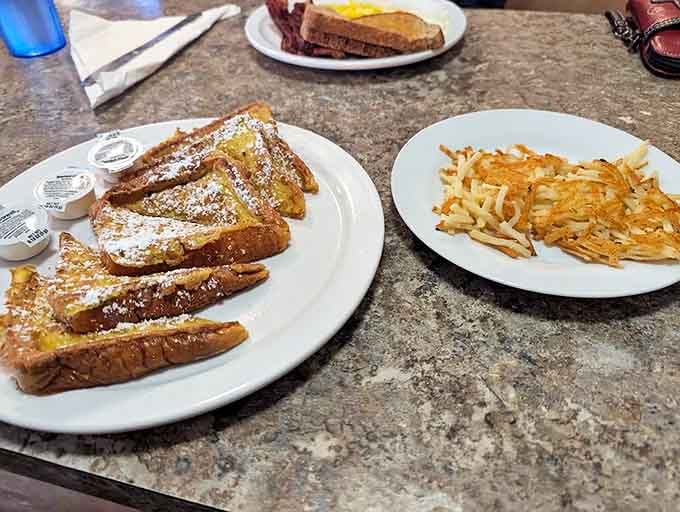 Golden-brown French toast dusted with powdered sugar alongside crispy hashbrowns. Morning indulgence that makes you wonder why we don't eat breakfast for every meal.