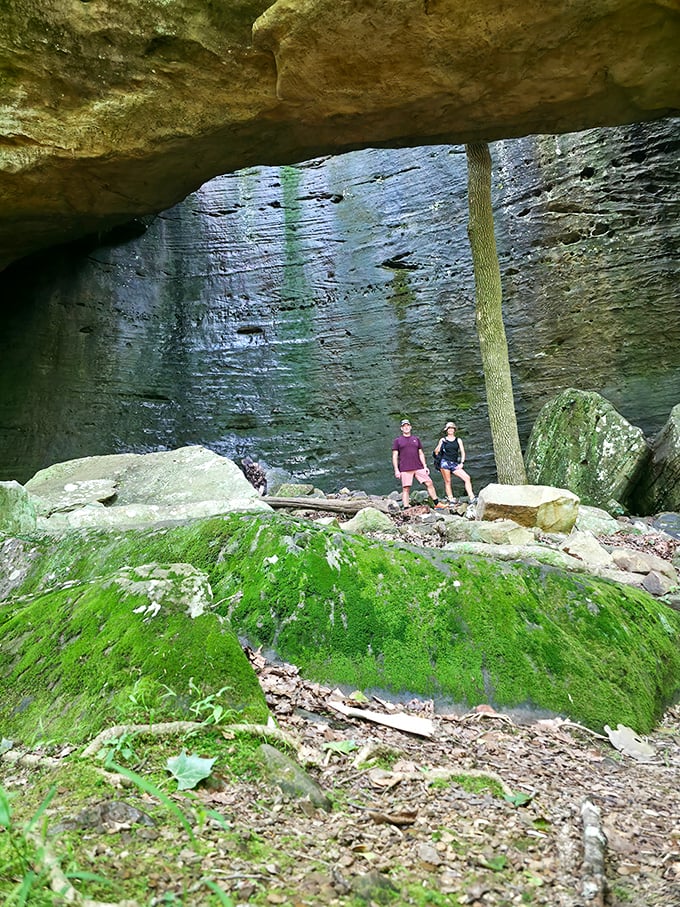Massive rock walls create a natural cathedral, dwarfing visitors who stand beneath these geological giants.