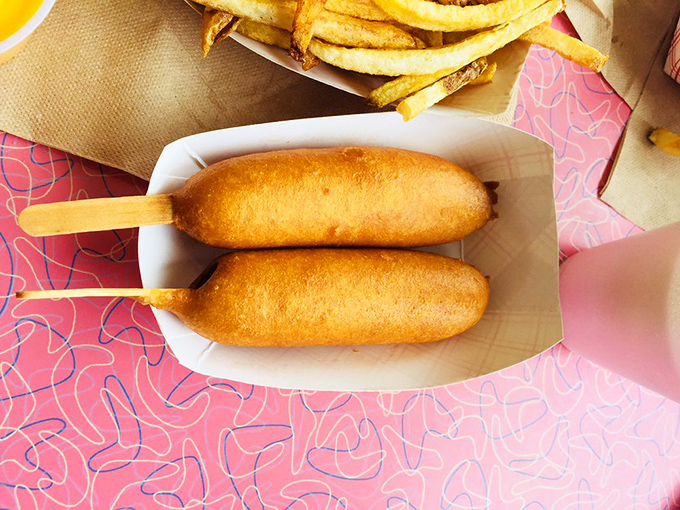 Golden perfection on a stick &ndash; two Cozy Dogs displaying that signature crispy exterior that shatters just right with each satisfying bite.