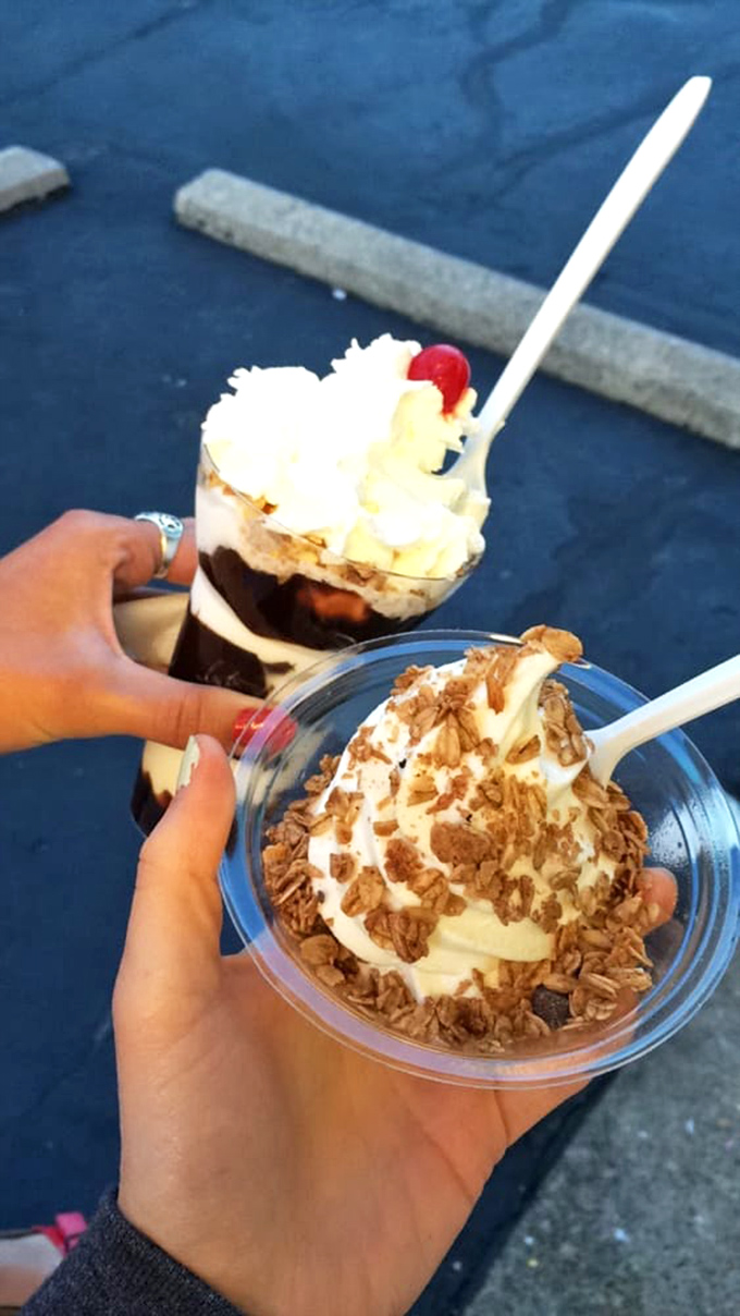 Two perfect sundaes ready for their close-up – one layered with hot fudge and nuts, the other showcasing golden crumbles atop creamy vanilla.