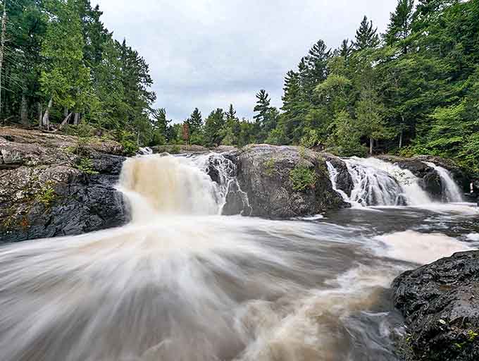 Dead River Falls creates a dramatic white ribbon against dark rocks, hypnotic in its endless dance.