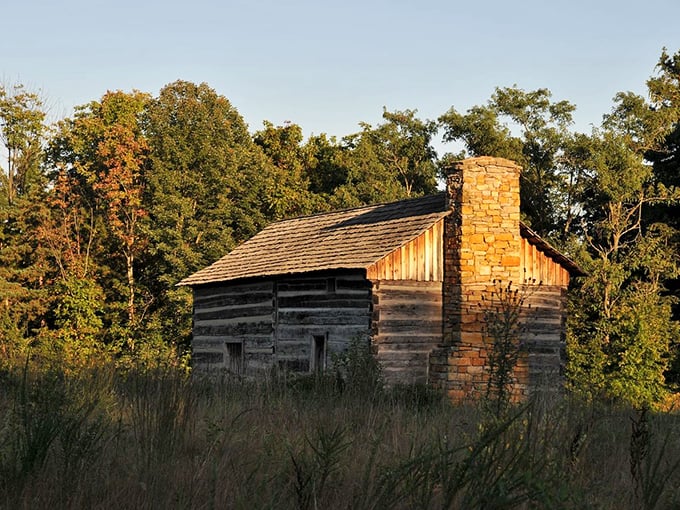 The historic Abner Hollow Cabin stands as a time capsule, its weathered logs telling stories of pioneers past.