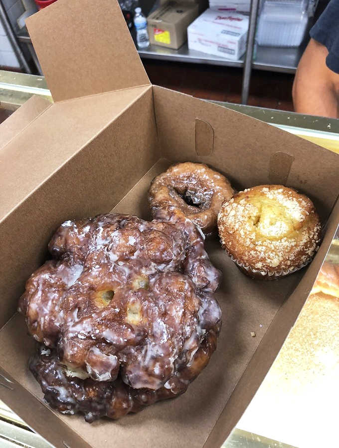 The holy trinity of morning indulgence: a fritter that could feed a family, a classic sour cream donut, and a sunshine-bright lemon muffin.