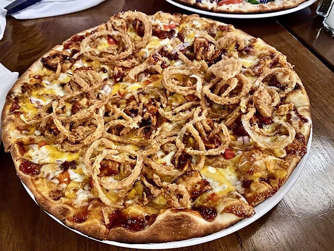 The BBQ Chicken pizza arrives topped with crispy onion strings that add a satisfying crunch to complement the tangy sauce.
