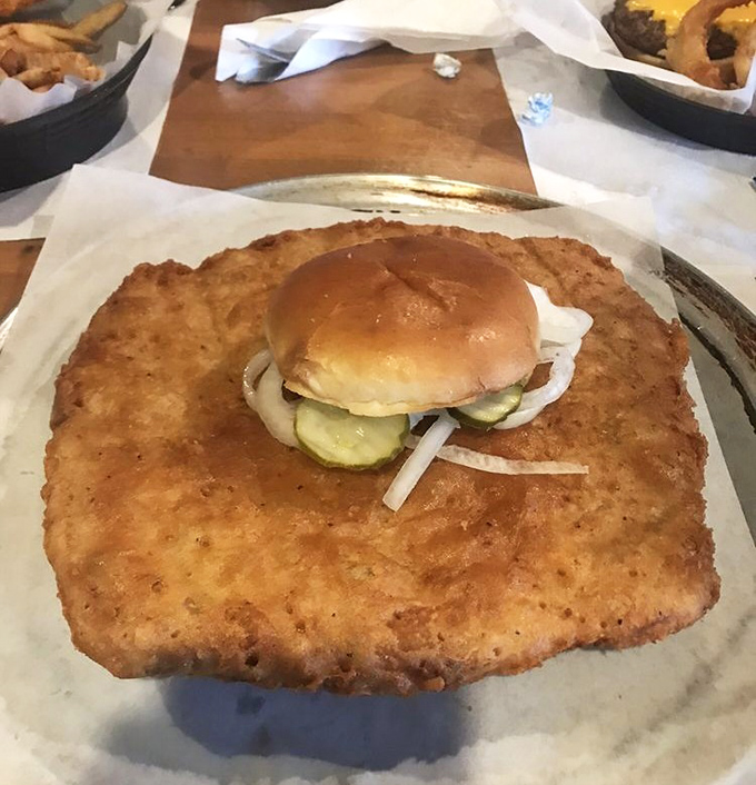 That tiny bun perched atop the massive breaded pork tenderloin isn't even pretending it can contain this magnificent beast.
