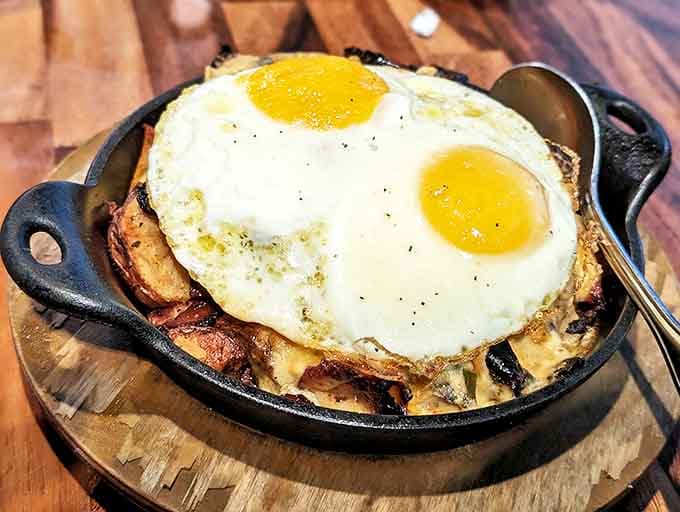 Morning glory on a skillet: eggs perched atop a mountain of breakfast potatoes and savory treasures.