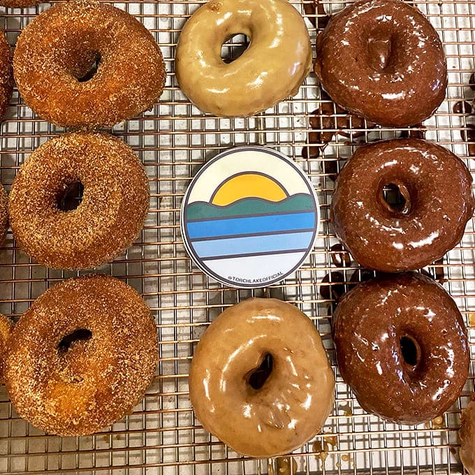 The holy trinity of donut perfection: chocolate glazed, maple frosted, and cinnamon sugar &ndash; a flavor adventure that makes the drive to Central Lake absolutely worth it.