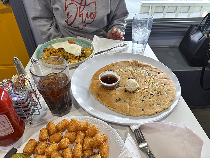 A bowl of hearty goodness topped with sunny-side-up eggs shares the spotlight with a pancake that refuses to be upstaged.