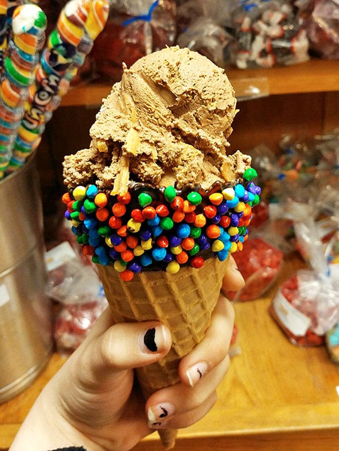 Chocolate ice cream meets rainbow-colored M&Ms in a cone collision that would make Willy Wonka himself slow-clap in approval.