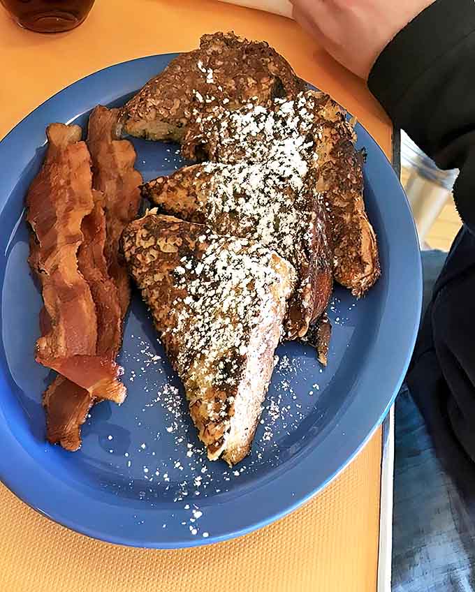 This isn't just French toast &ndash; it's a cinnamon-raisin revelation dusted with powdered sugar and served with crispy bacon that'll ruin all other breakfasts forever.