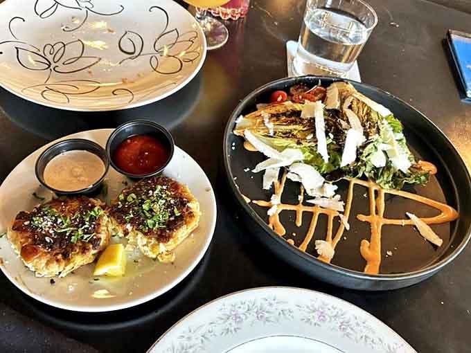 A study in contrasts: delicate crab cakes with their crispy exterior alongside a vibrant salad that proves vegetables needn't be boring supporting characters.
