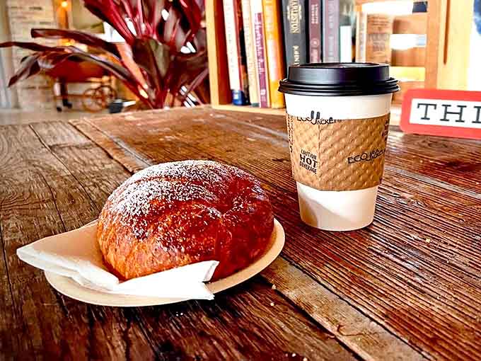 Buttery layers shatter with each bite of this perfectly executed croissant, paired with a steaming cup of comfort in a rustic setting.