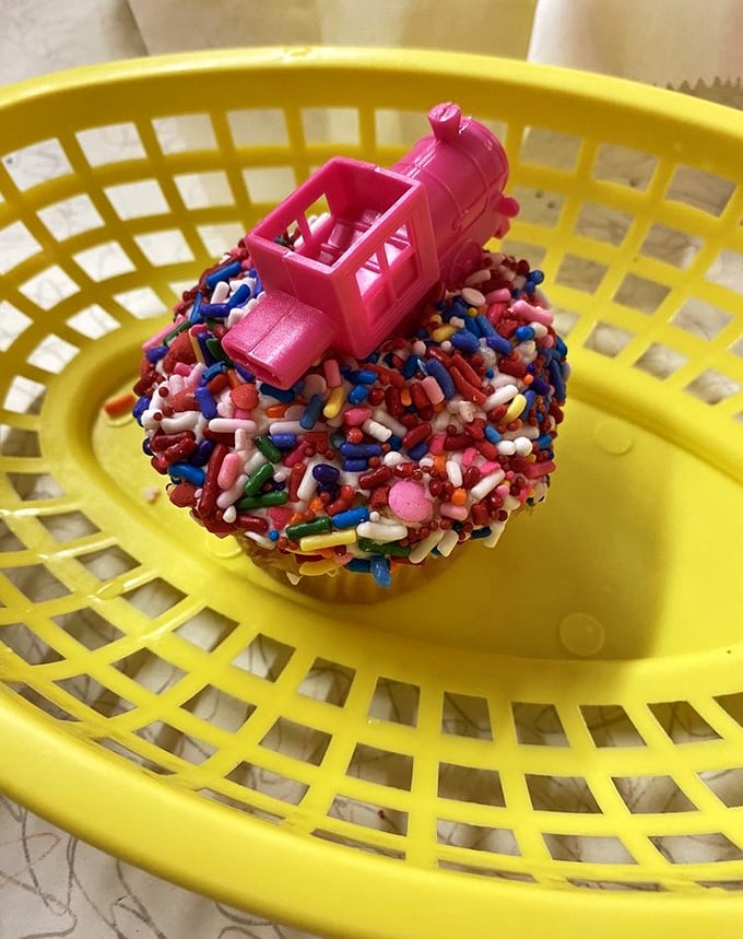 Cupcake: Childhood joy in edible form &ndash; rainbow sprinkles cascade around a tiny train engine, proving desserts can be both delicious and smile-inducing.