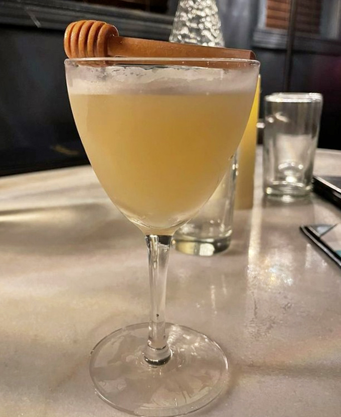 Honey-hued perfection topped with a wooden honey dipper – this cocktail doesn't just taste sweet, it tells a story.