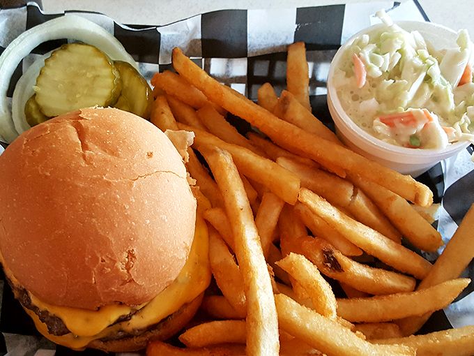 The perfect diner trifecta: a juicy cheeseburger, golden fries, and creamy coleslaw that would make any food critic weep with joy.