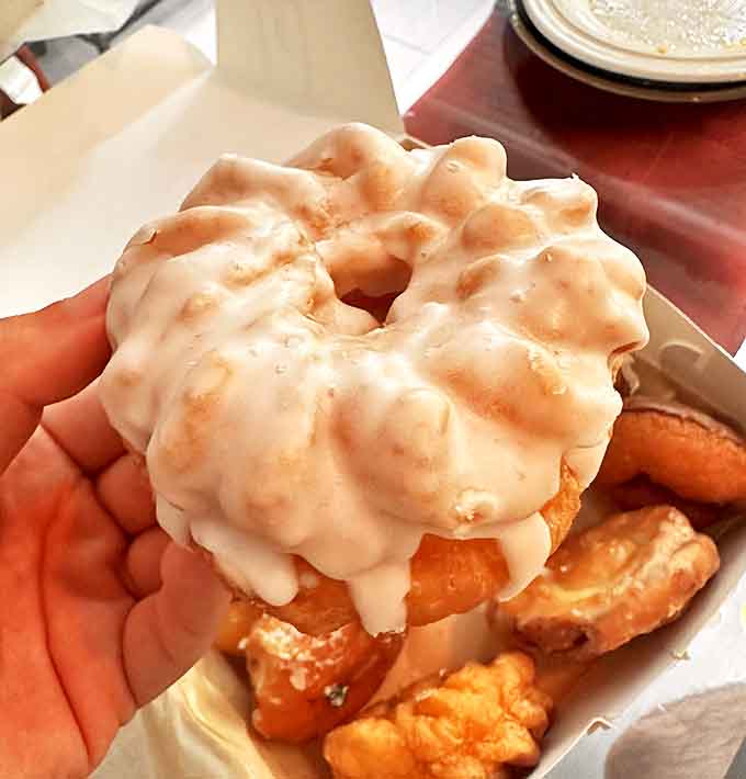 This vanilla-glazed masterpiece exemplifies donut perfection &ndash; its rippled surface catching the light like edible stained glass.