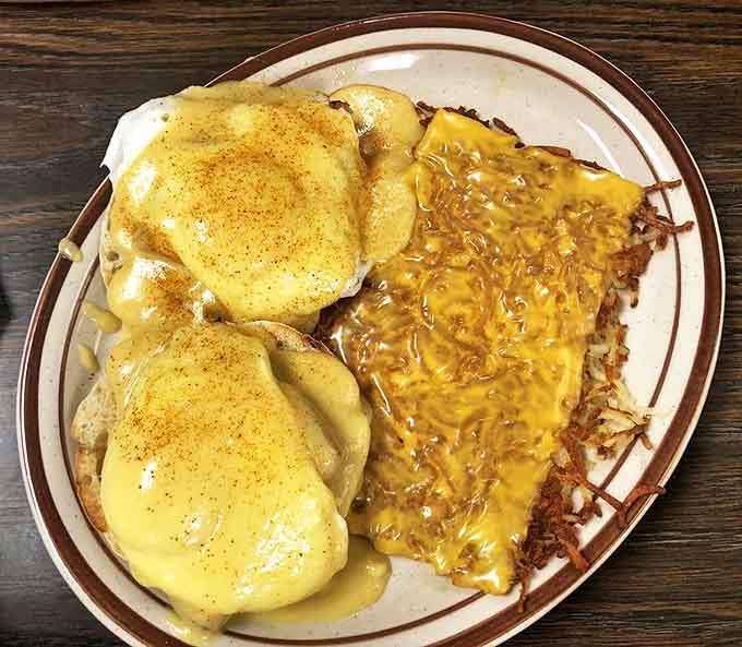 Eggs Benedict with cheesy hash browns: where hollandaise sauce meets potato perfection in a breakfast romance that puts most Hollywood love stories to shame.