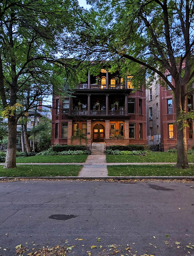 Twilight transforms this Summit Avenue brownstone into a magical tableau – windows glowing with warmth against the approaching evening.