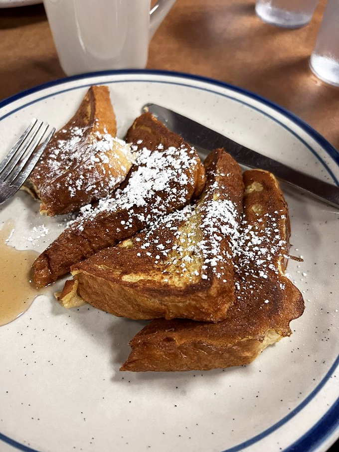 French toast that would make your grandmother proud &ndash; thick-cut, golden-brown, and dusted with powdered sugar waiting for maple syrup.