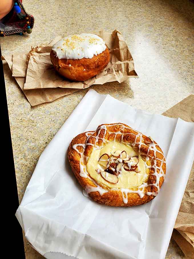 These fruit-filled pastries look like someone captured sunshine and baked it into flaky, golden perfection, then added almonds for good measure.