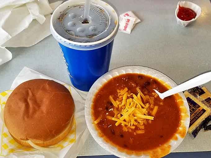 The perfect partnership &ndash; a hearty burger alongside homestyle chili topped with melted cheese, with a cold drink standing by.