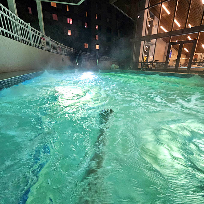 The heated outdoor pool glows with invitation at night, creating that magical moment when swimming under stars meets winter defiance.