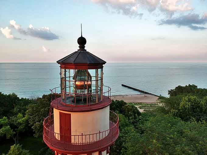 Sunset bathes the lighthouse in golden hour magic, its silhouette standing watch as it has since 1873, a timeless guardian against Lake Michigan's notoriously fickle moods.
