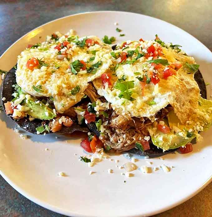 Huevos rancheros that would make abuela proud &ndash; crispy tortillas, perfectly runny eggs, and fresh toppings creating a breakfast fiesta on a plate.